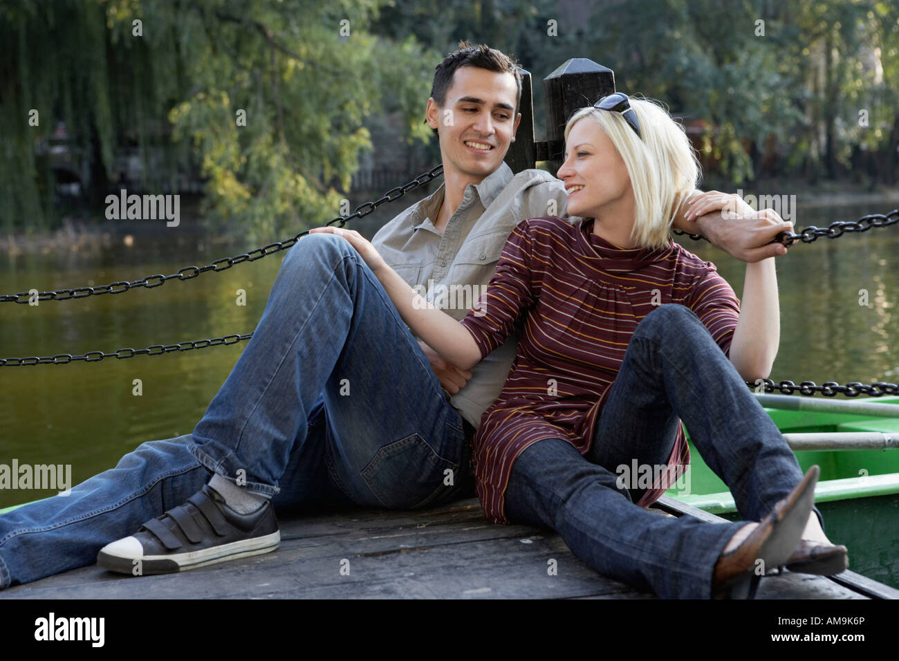 Couple on a dock smiling and relaxing Stock Photo - Alamy