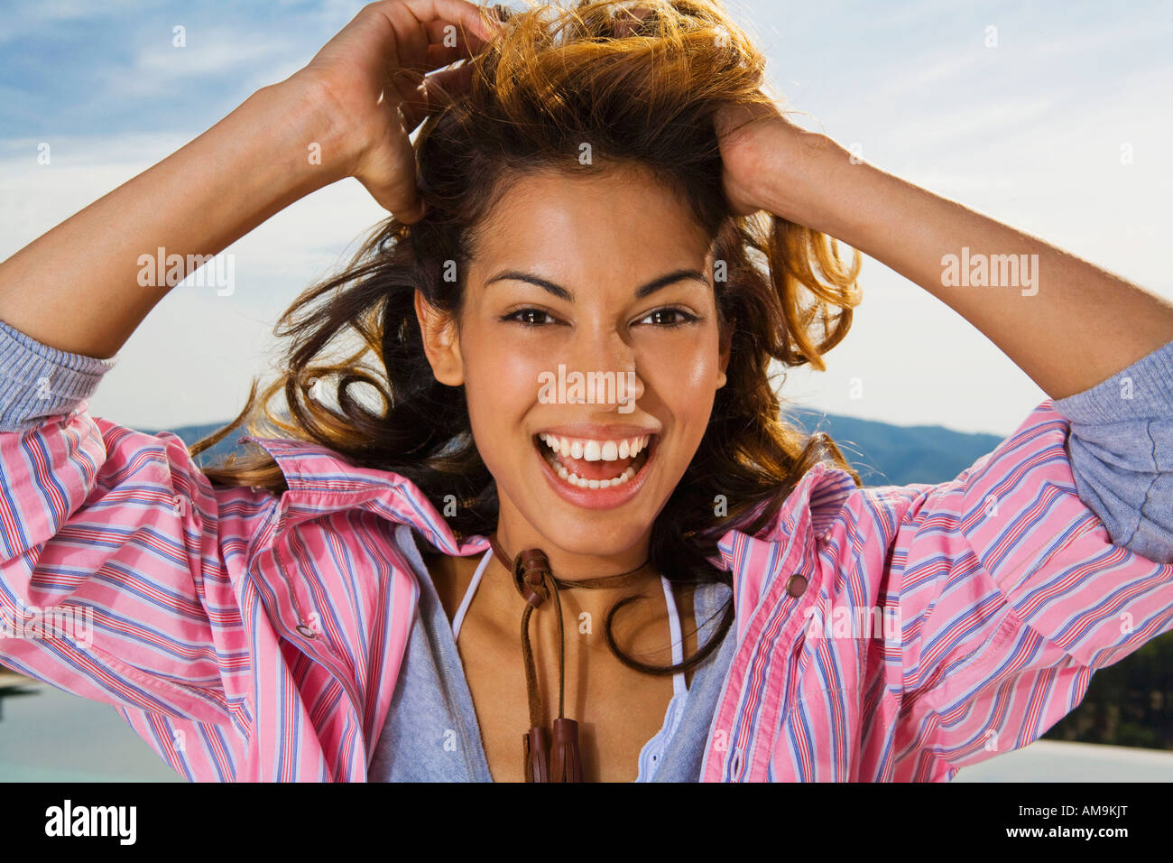 Dynamic woman smiles outside hand sin hair Stock Photo - Alamy