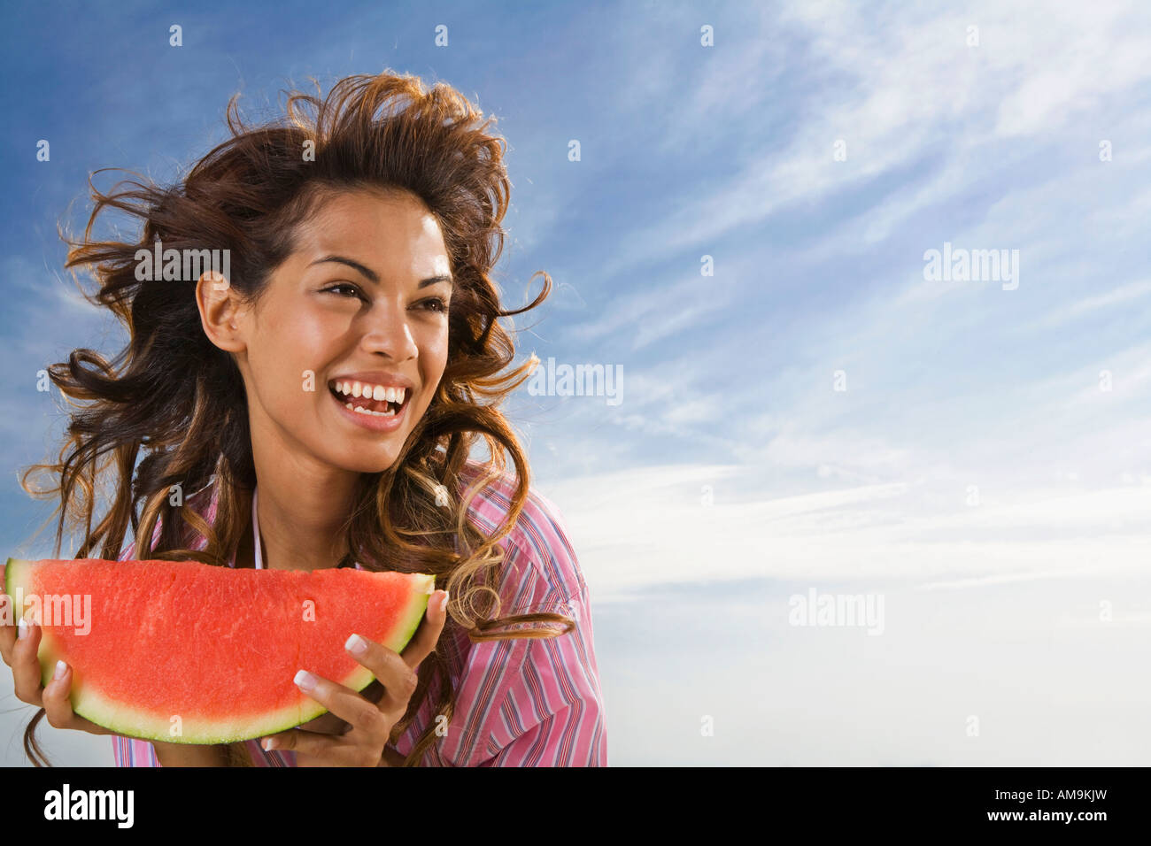 Woman laughing and eating watermelon outdoors Stock Photo - Alamy