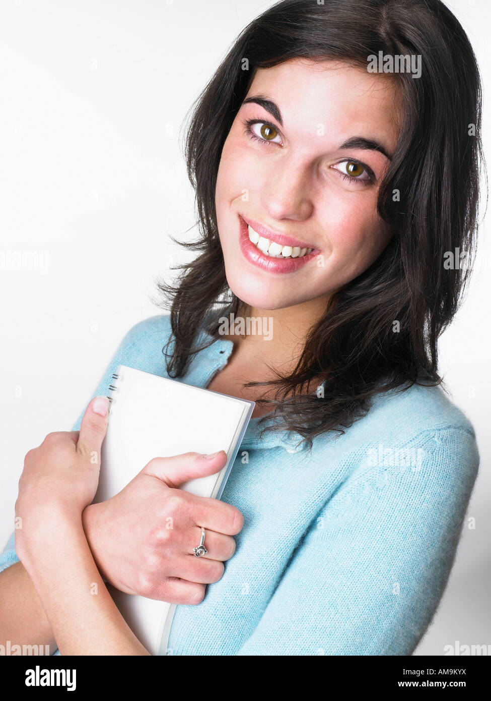 Woman smiling holding a notebook Stock Photo - Alamy