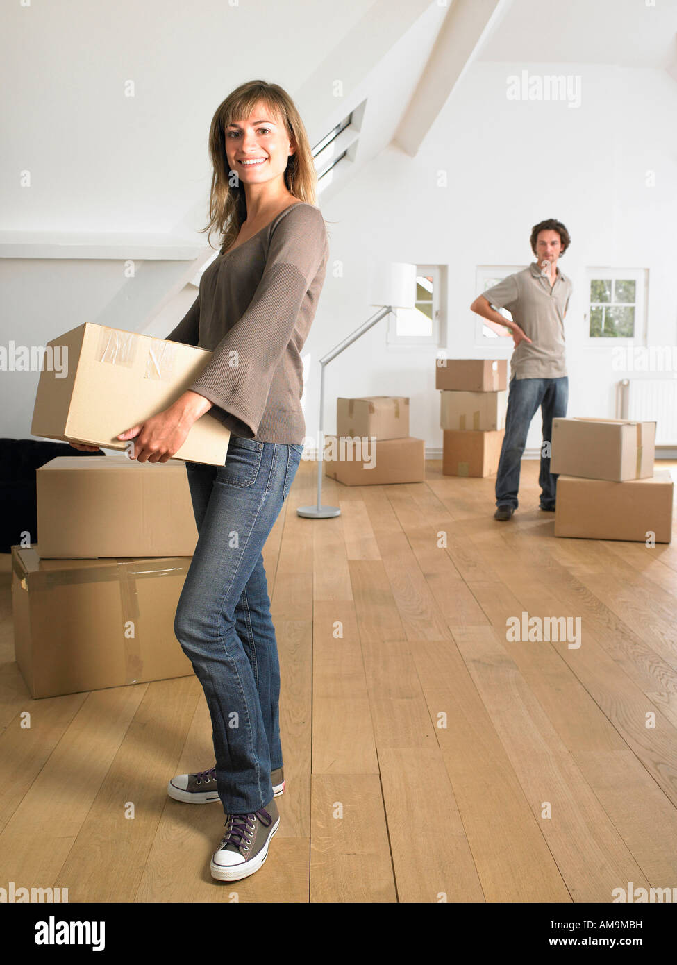 Couple moving into new home smiling Stock Photo - Alamy