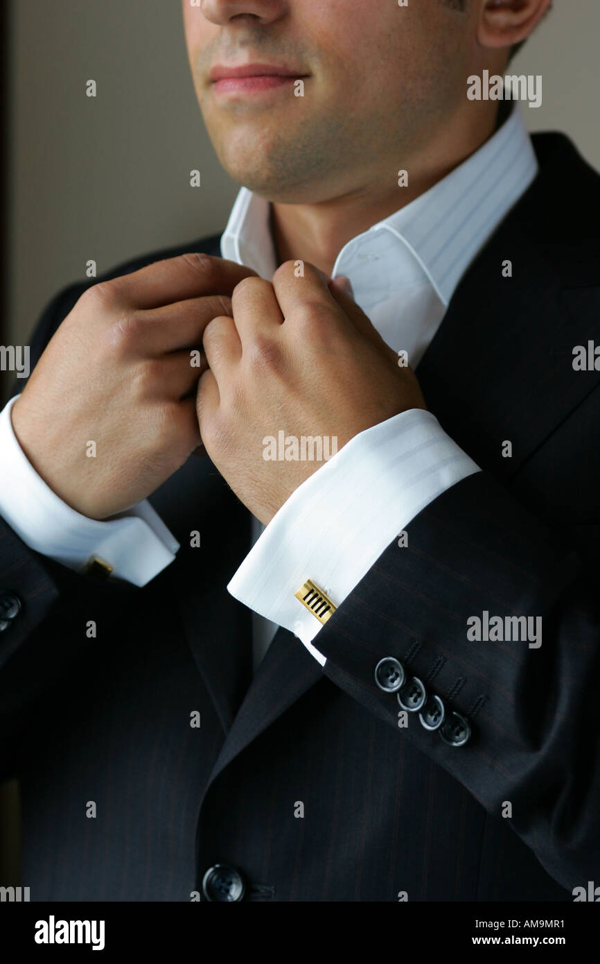 A portrait of a businessman ajusting the tie around his kneck before ...