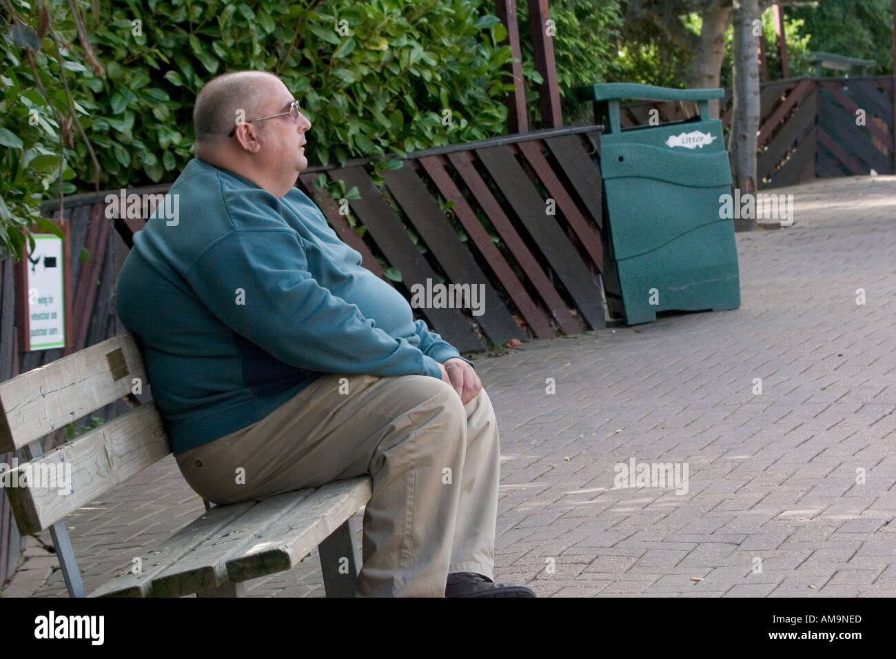 Large man resting on bench Stock Photo - Alamy