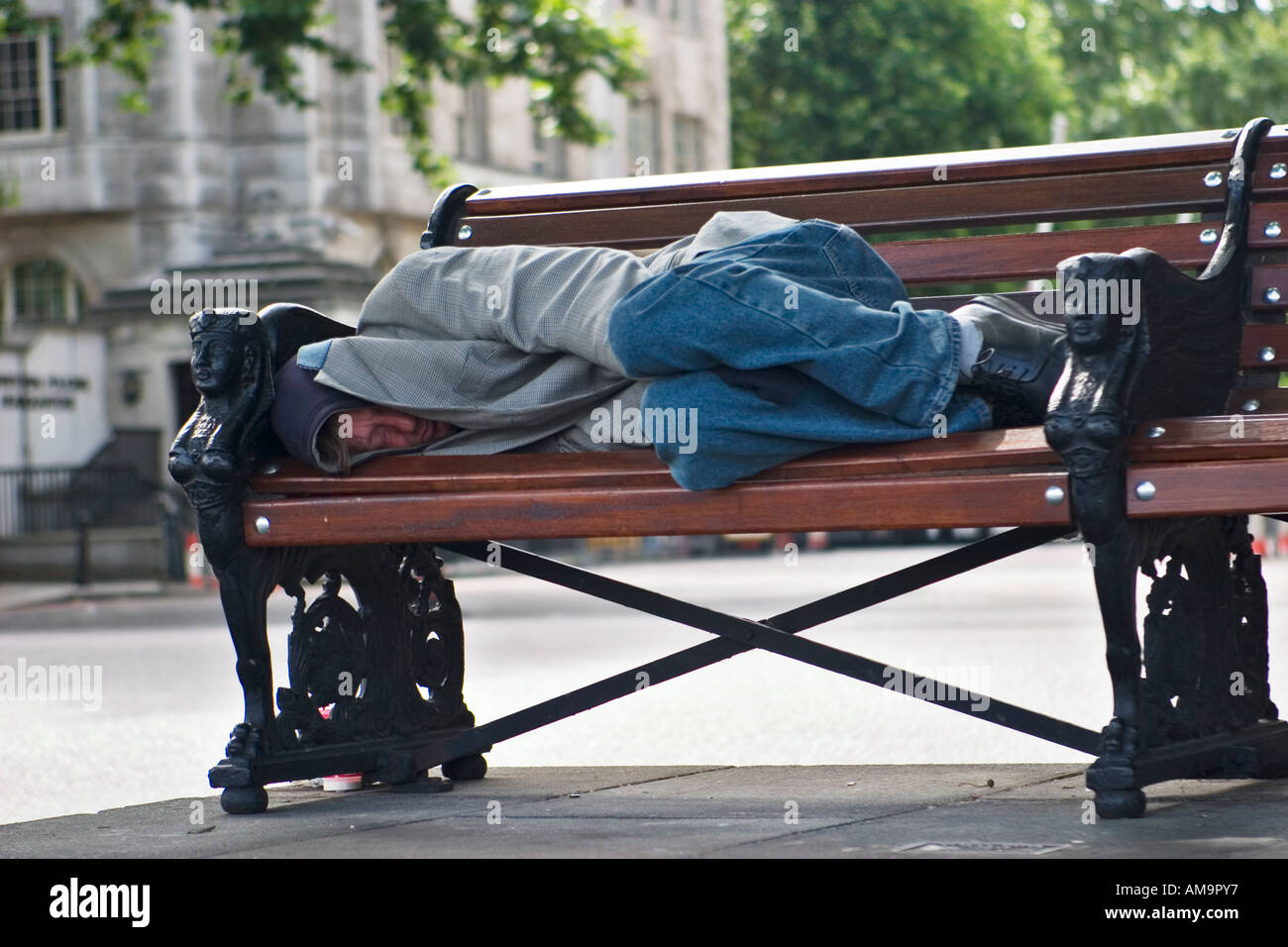 Homeless man sleeps on bench on Embankment London Stock Photo - Alamy
