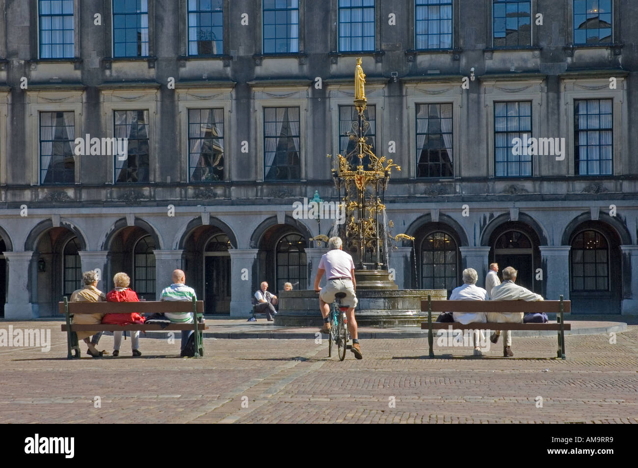 Tourists sat on the benches in the courtyard of the Binnehof, Dutch ...