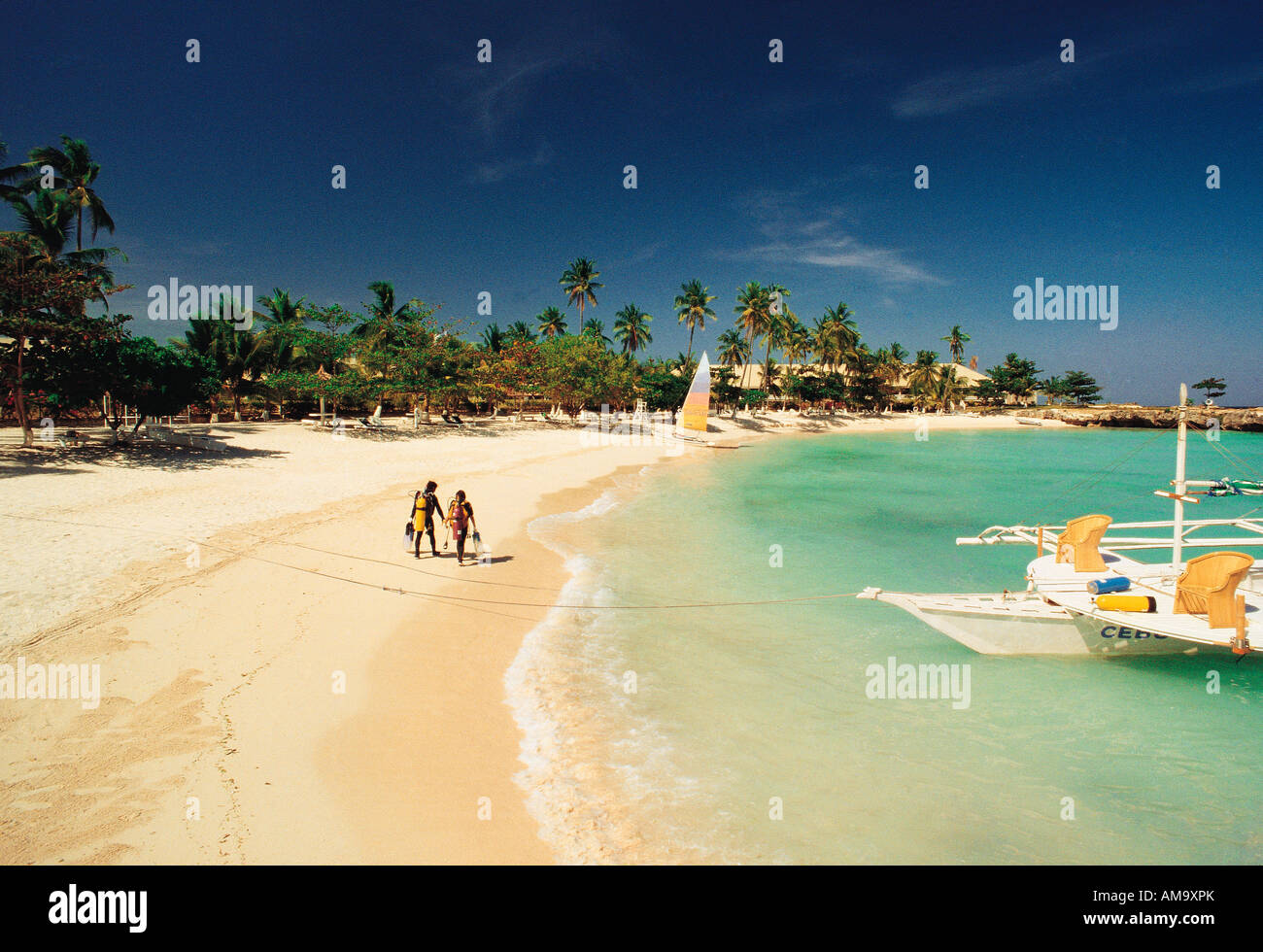 Philippines. Cebu. Beach resort scene with young couple in dive gear ...