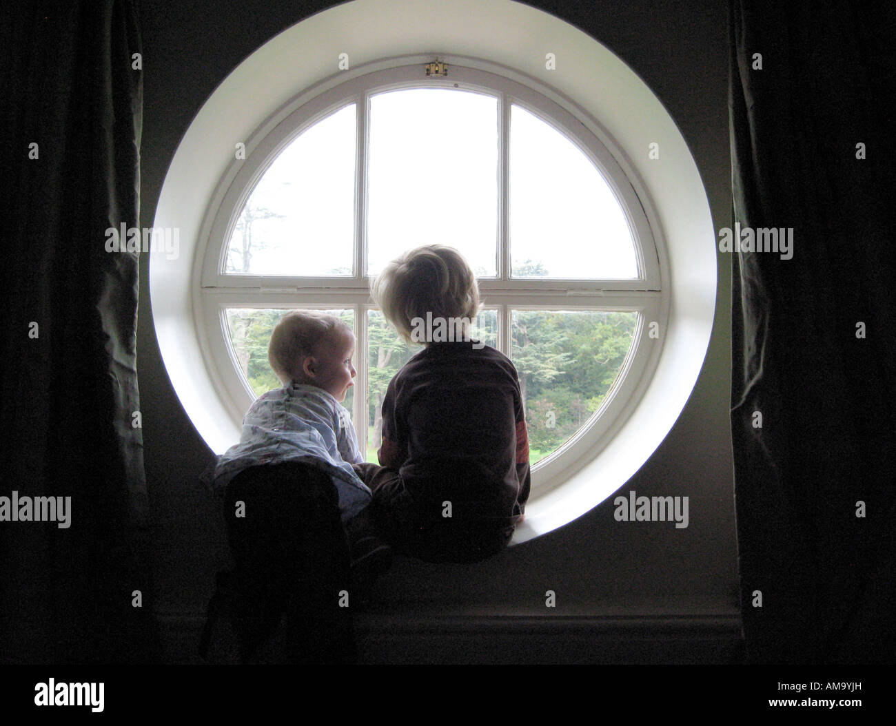 Children looking out of window Stock Photo - Alamy