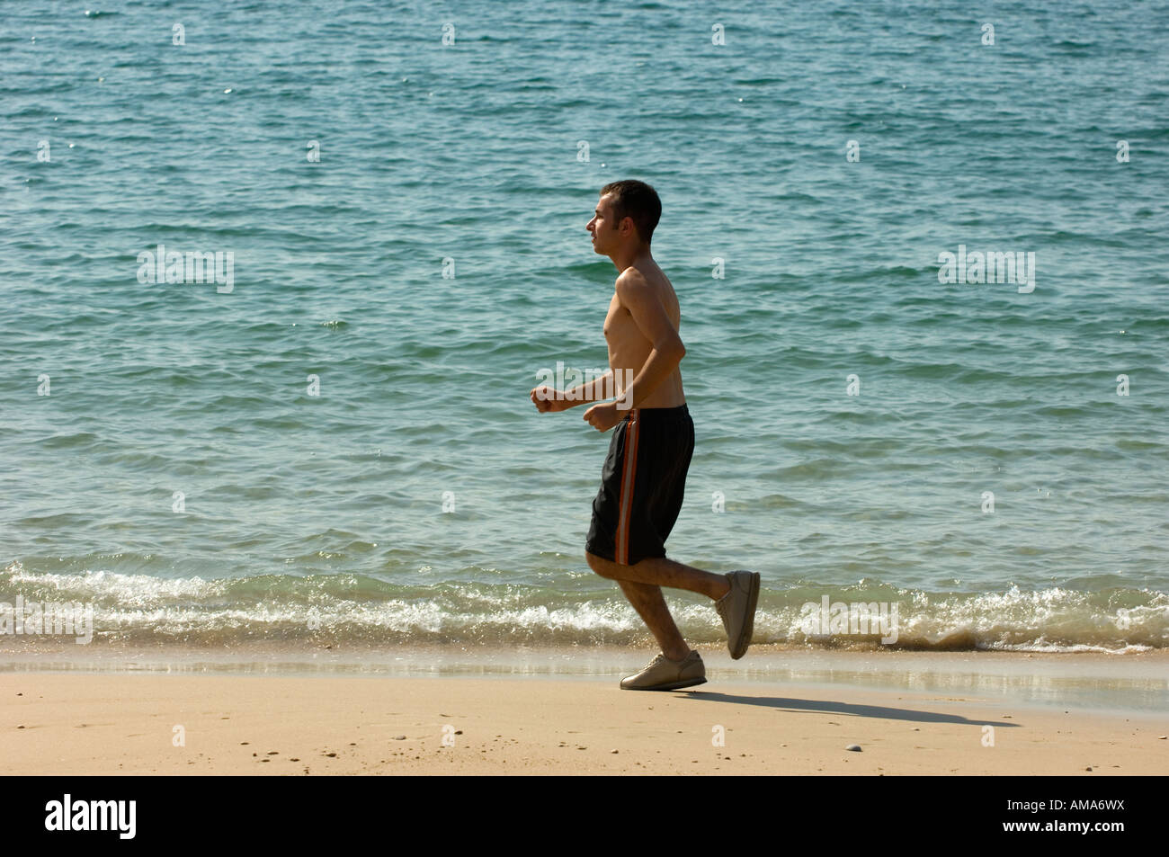 young man running at the beach Stock Photo - Alamy