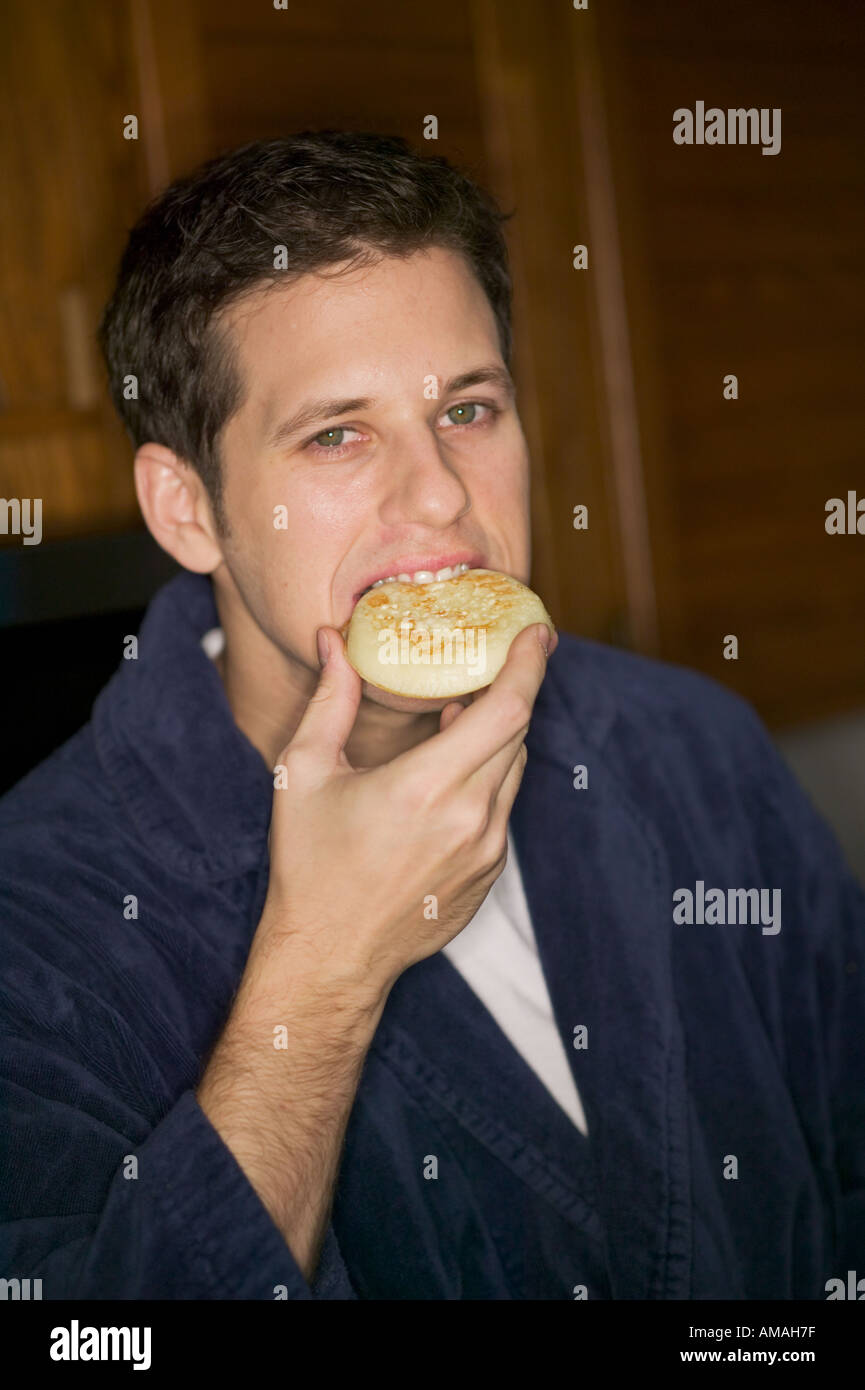 Man eating toasted crumpet Stock Photo - Alamy