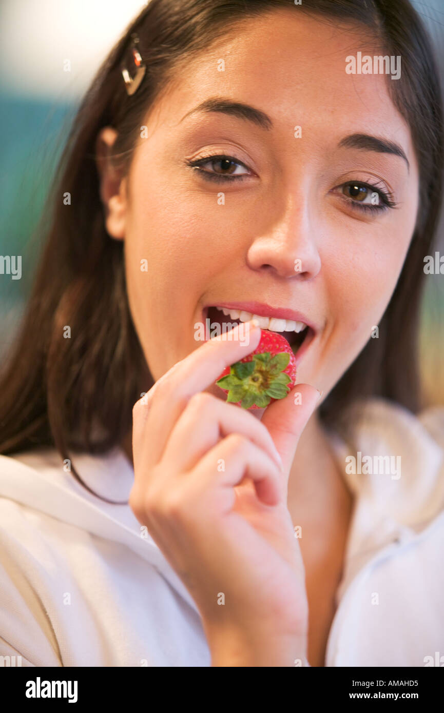 Woman eating strawberry Stock Photo - Alamy