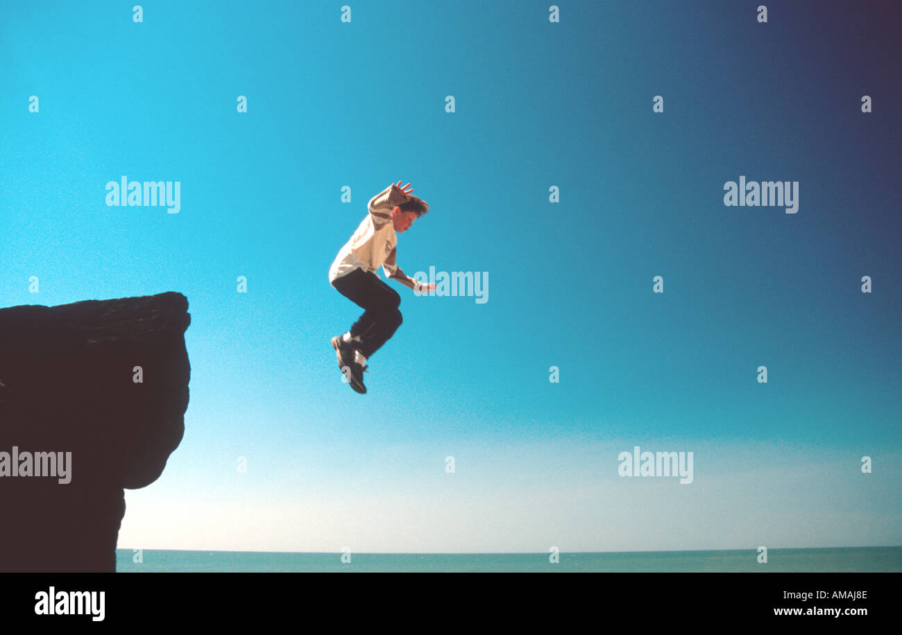 Boy jumping off rocks hi-res stock photography and images - Alamy