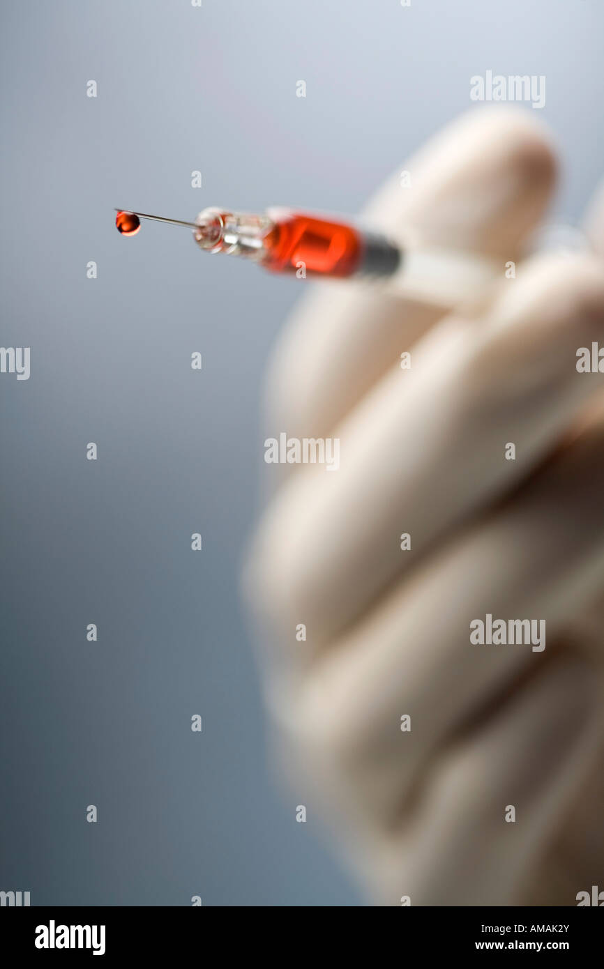 A hand holding a syringe Stock Photo - Alamy