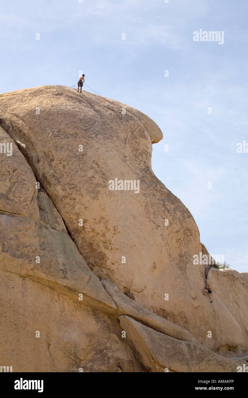 Two people abseiling down on a rocky cliff Stock Photo - Alamy