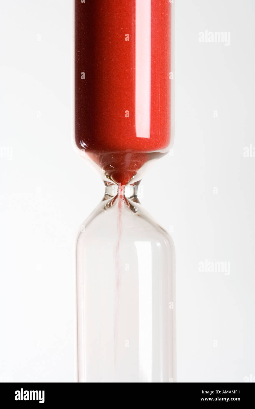 Sand falling through an hourglass Stock Photo - Alamy