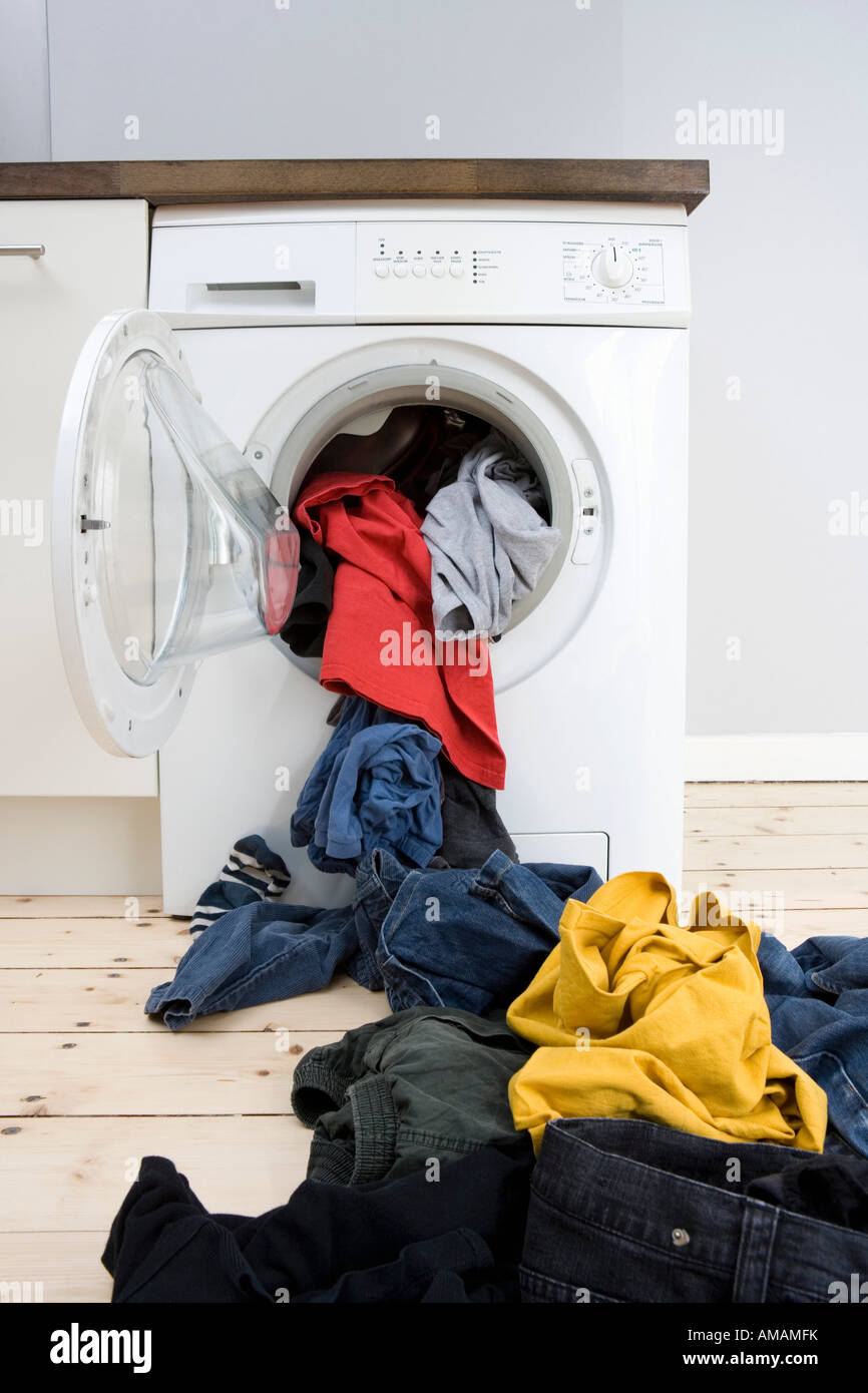 Laundry spilling out of a washer dryer Stock Photo - Alamy