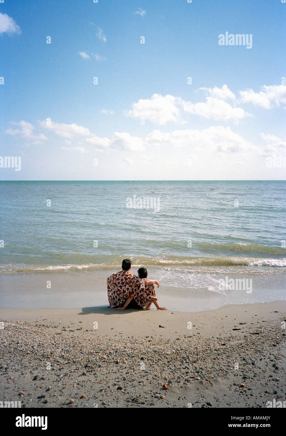 A couple sitting on the beach together Stock Photo - Alamy