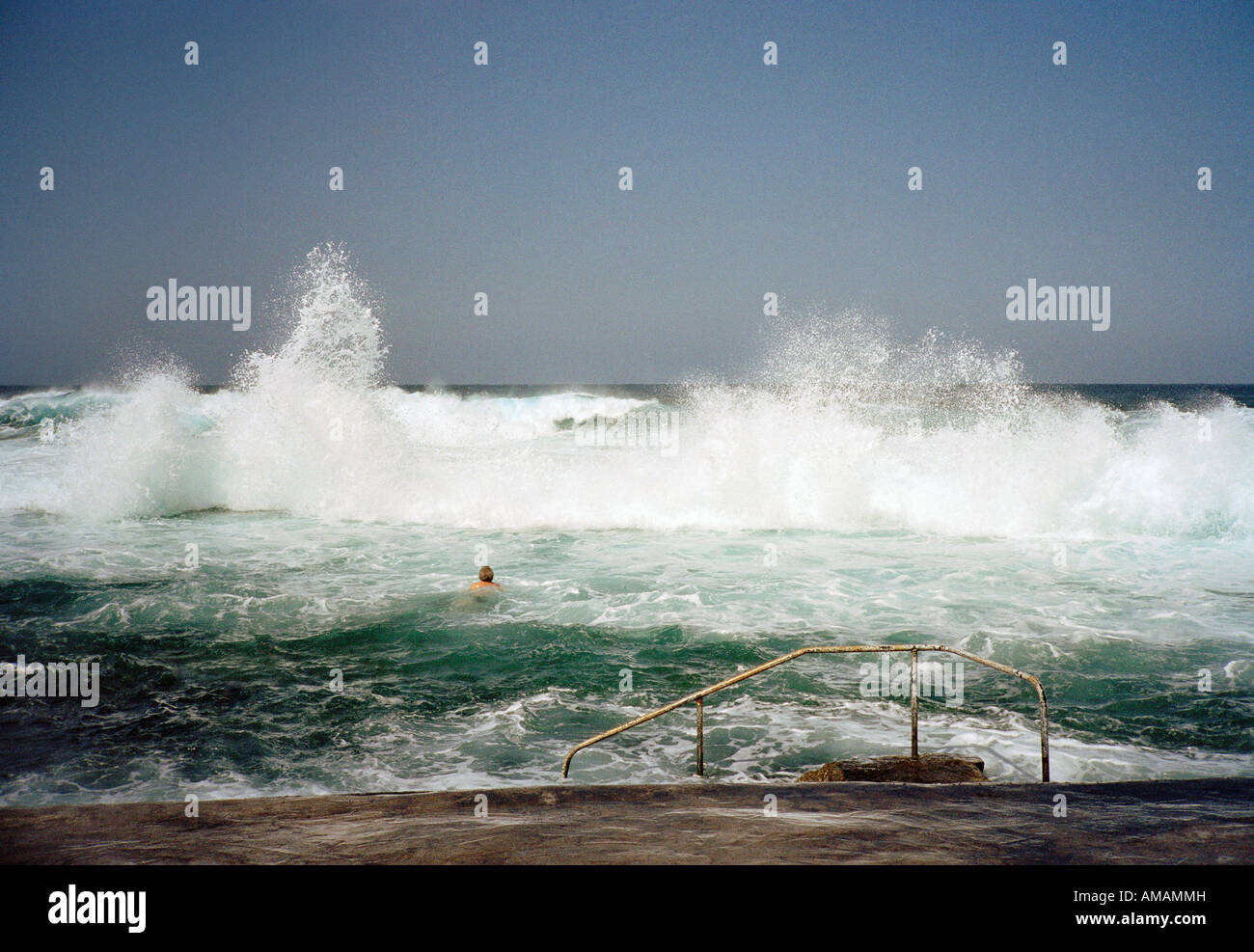 A person swimming into crashing waves Stock Photo - Alamy