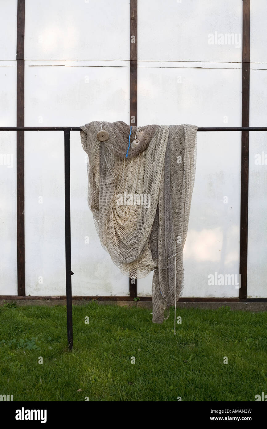 A fishing net hanging on railing Stock Photo - Alamy