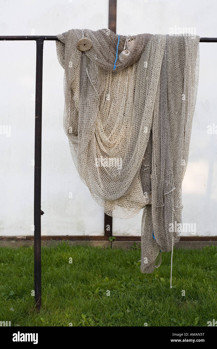 A fishing net hanging on railing Stock Photo - Alamy