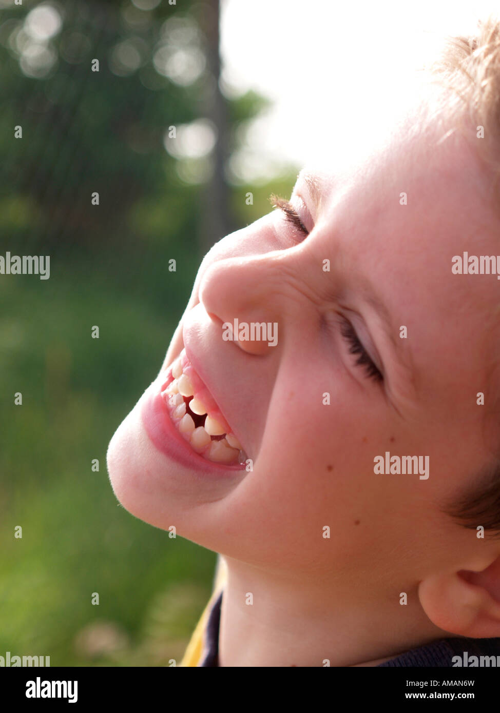 side view of young boy grinning tilting head backwards Stock Photo - Alamy