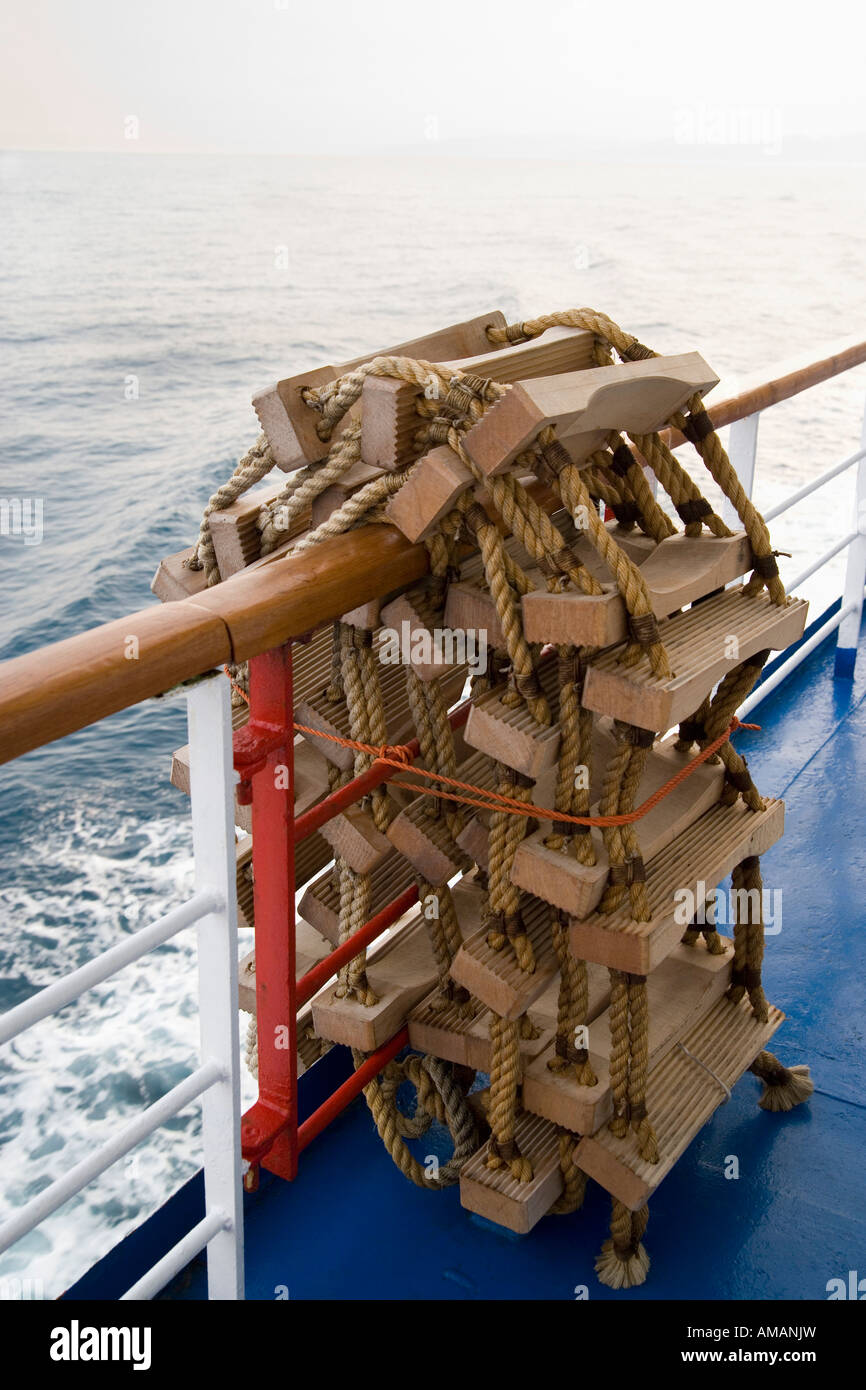 A rope ladder rolled up over a ship railing Stock Photo - Alamy