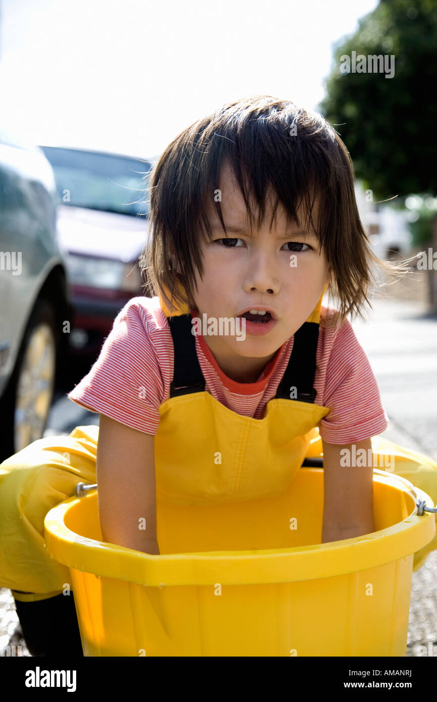 A young boy with his hands in a plastic bucket Stock Photo - Alamy