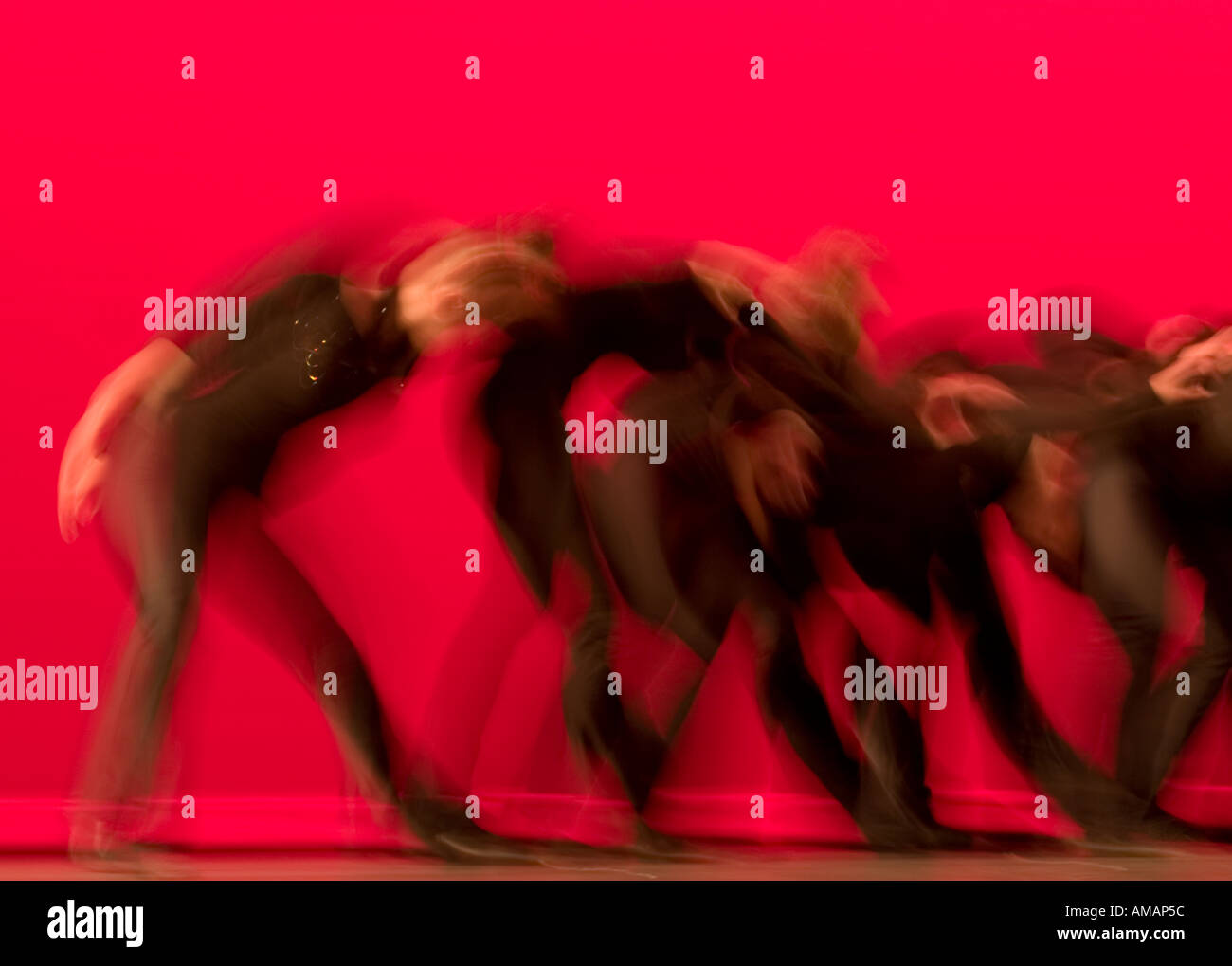 Group of teenage dancers in red and black costumes moving ...