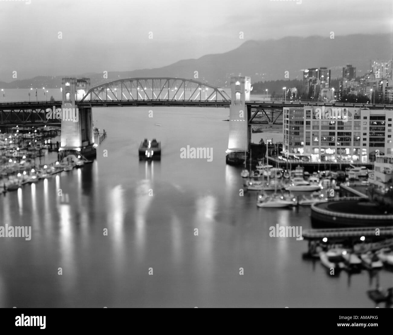 A barge passing under a bridge next to a marina Stock Photo - Alamy