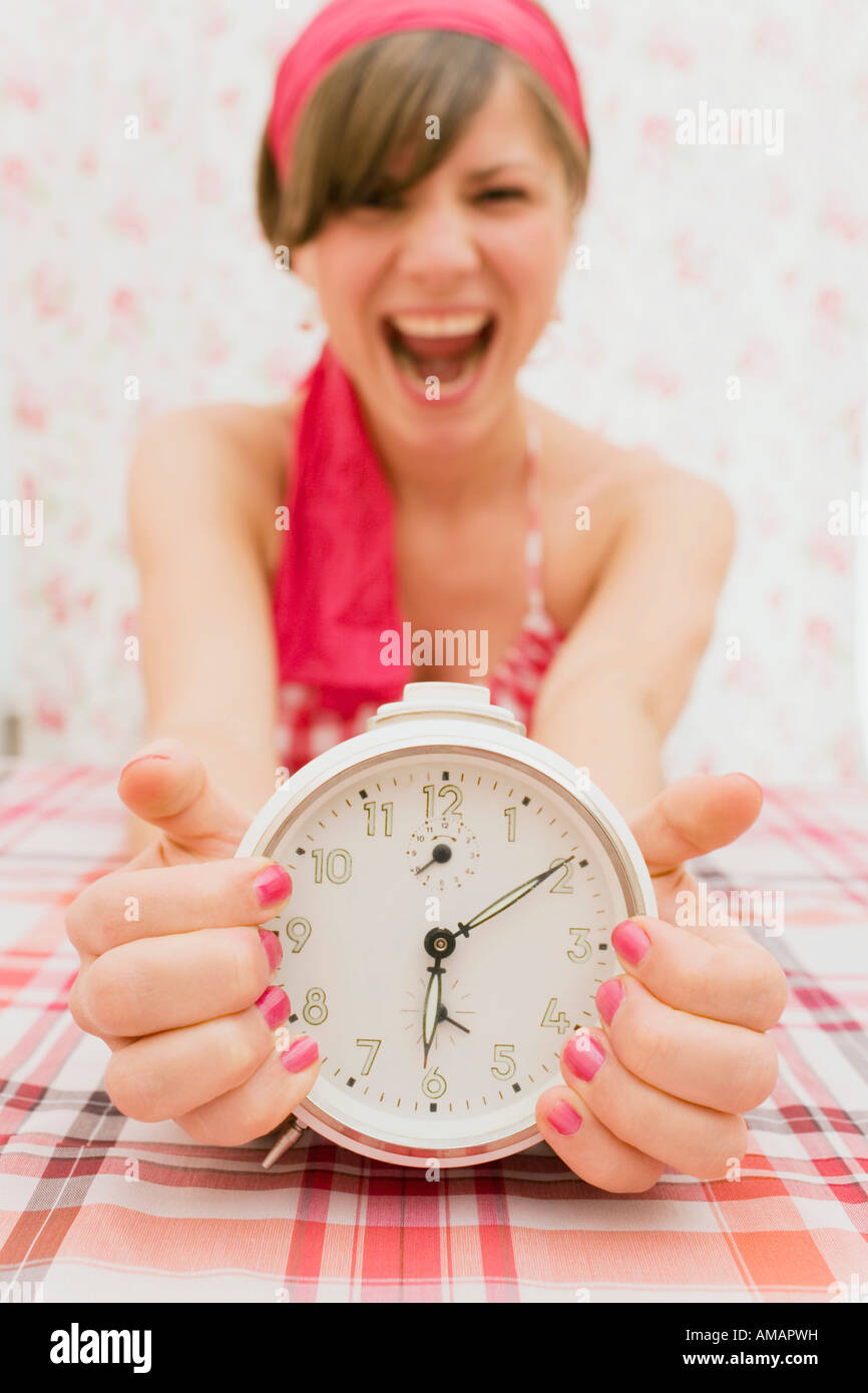 A young woman holding a clock and shouting Stock Photo - Alamy