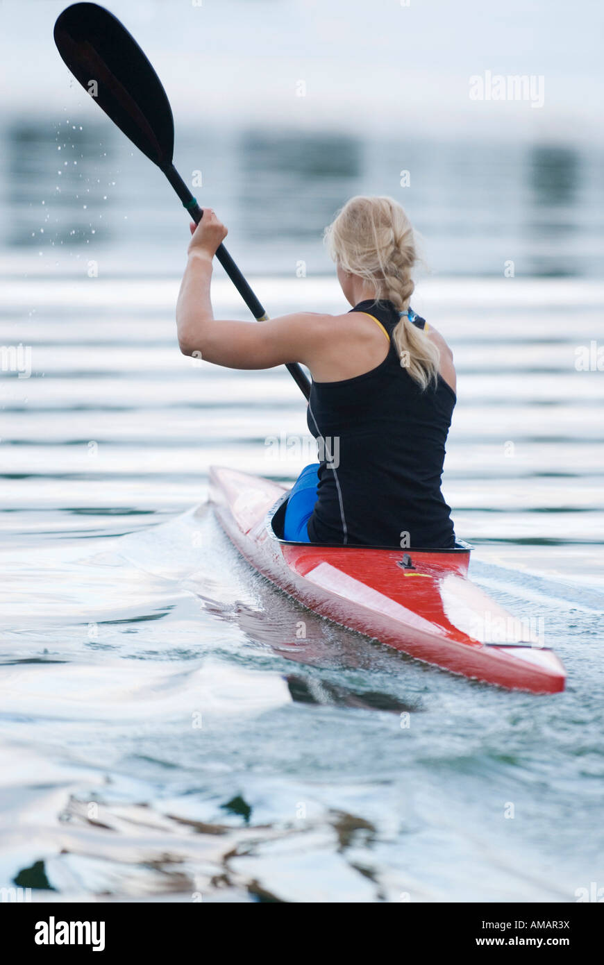 Rear view of a woman kayaking Stock Photo - Alamy
