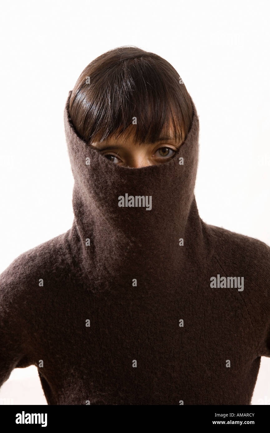 A young woman pulling a turtleneck over her head Stock Photo - Alamy