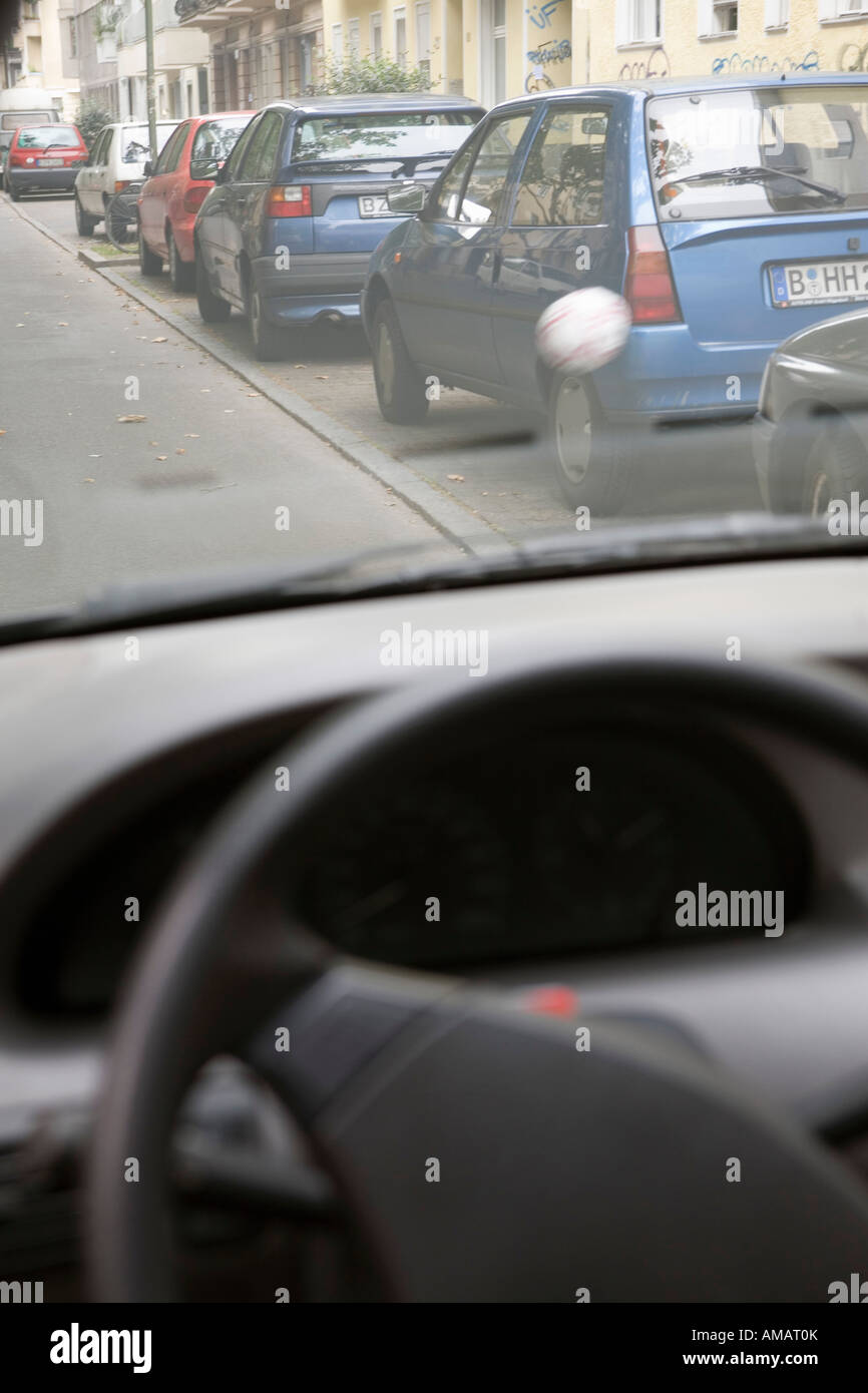 A ball bouncing in front of a car driving along a street Stock Photo ...