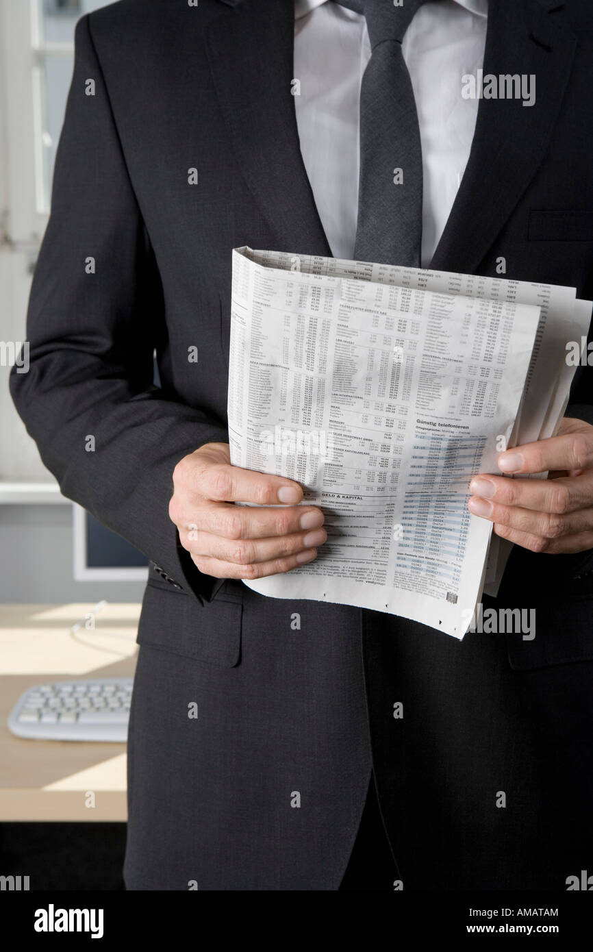 A businessman holding a newspaper Stock Photo - Alamy