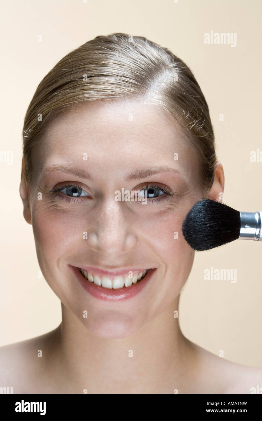 A woman applying face powder Stock Photo - Alamy