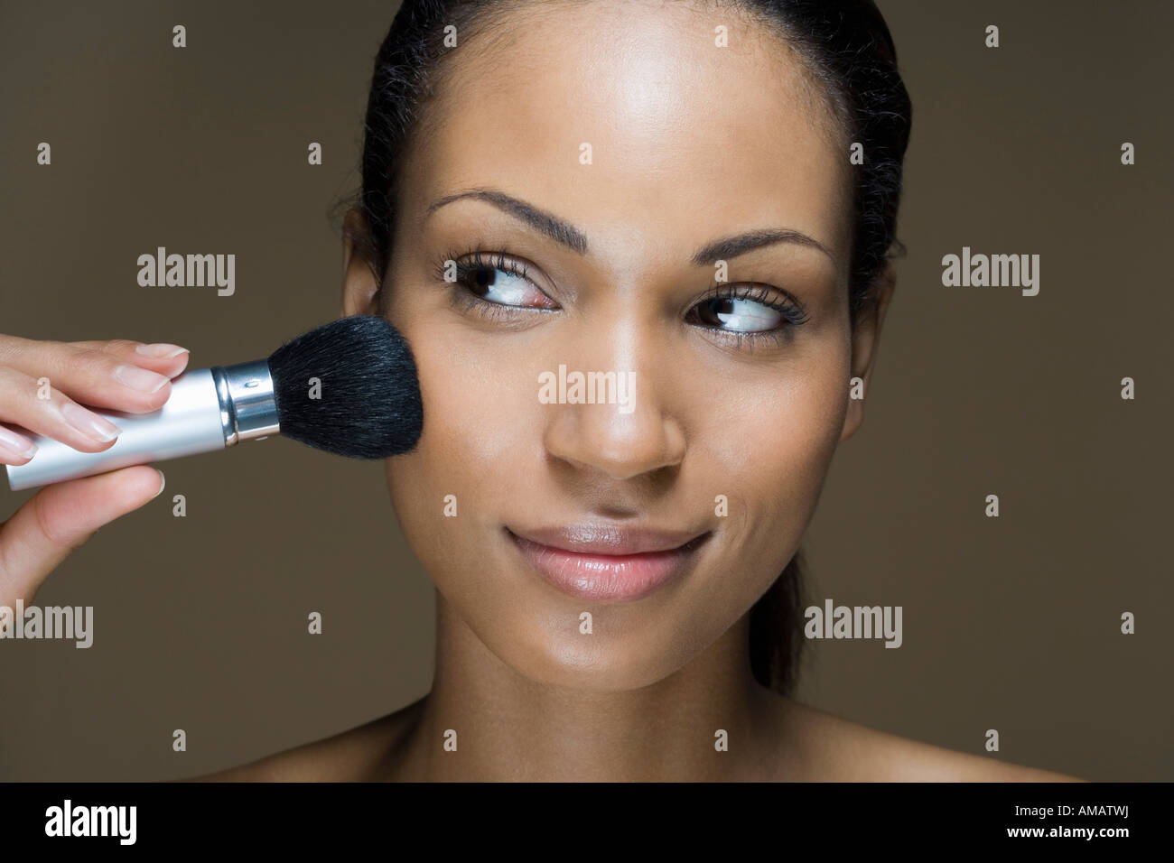 A woman applying face powder Stock Photo - Alamy
