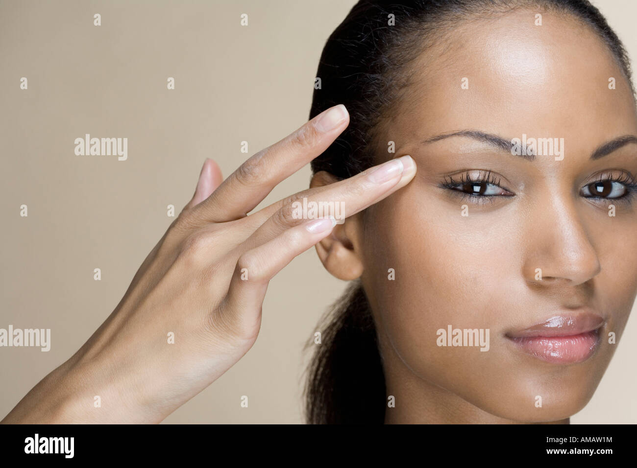 A woman touching her temple Stock Photo - Alamy