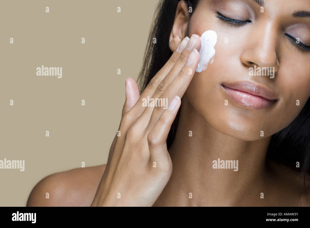 A woman rubbing moisturizer into her skin Stock Photo - Alamy