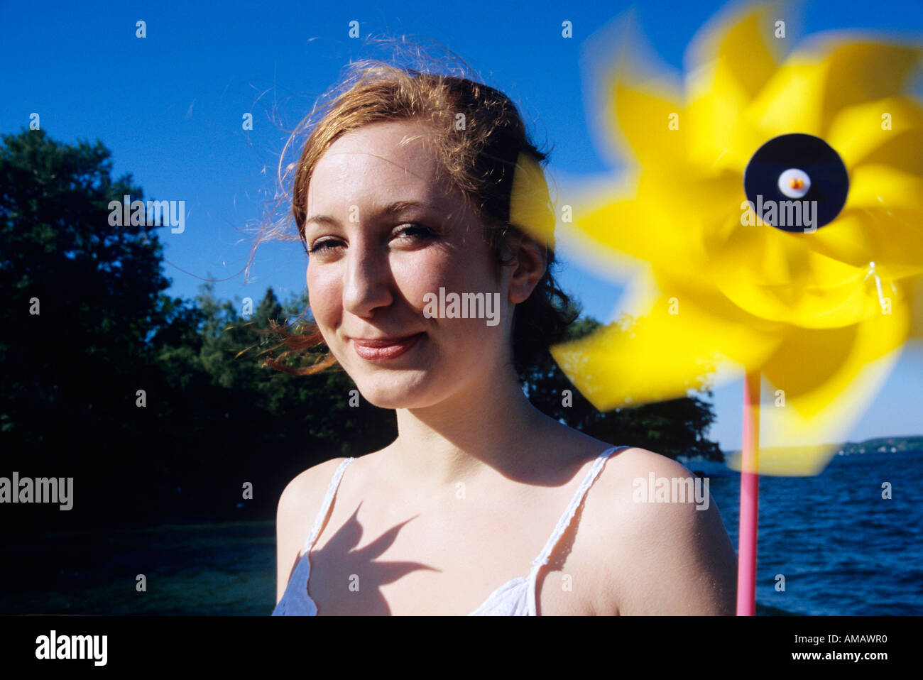 Young woman holding pin wheel, smiling, portrait Stock Photo - Alamy