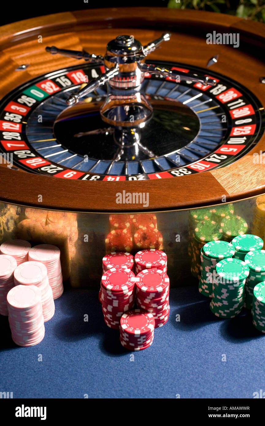 Roulette wheel with stacks of gambling chips Stock Photo - Alamy