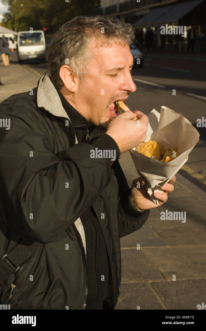 man eating fish and chips in London Stock Photo - Alamy