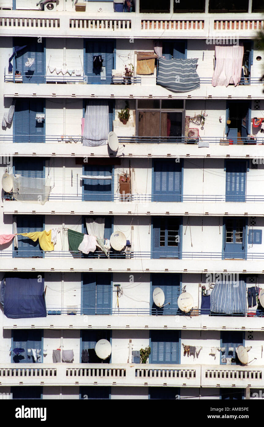 View of an apartment building facade with satellite dishes and hanging ...