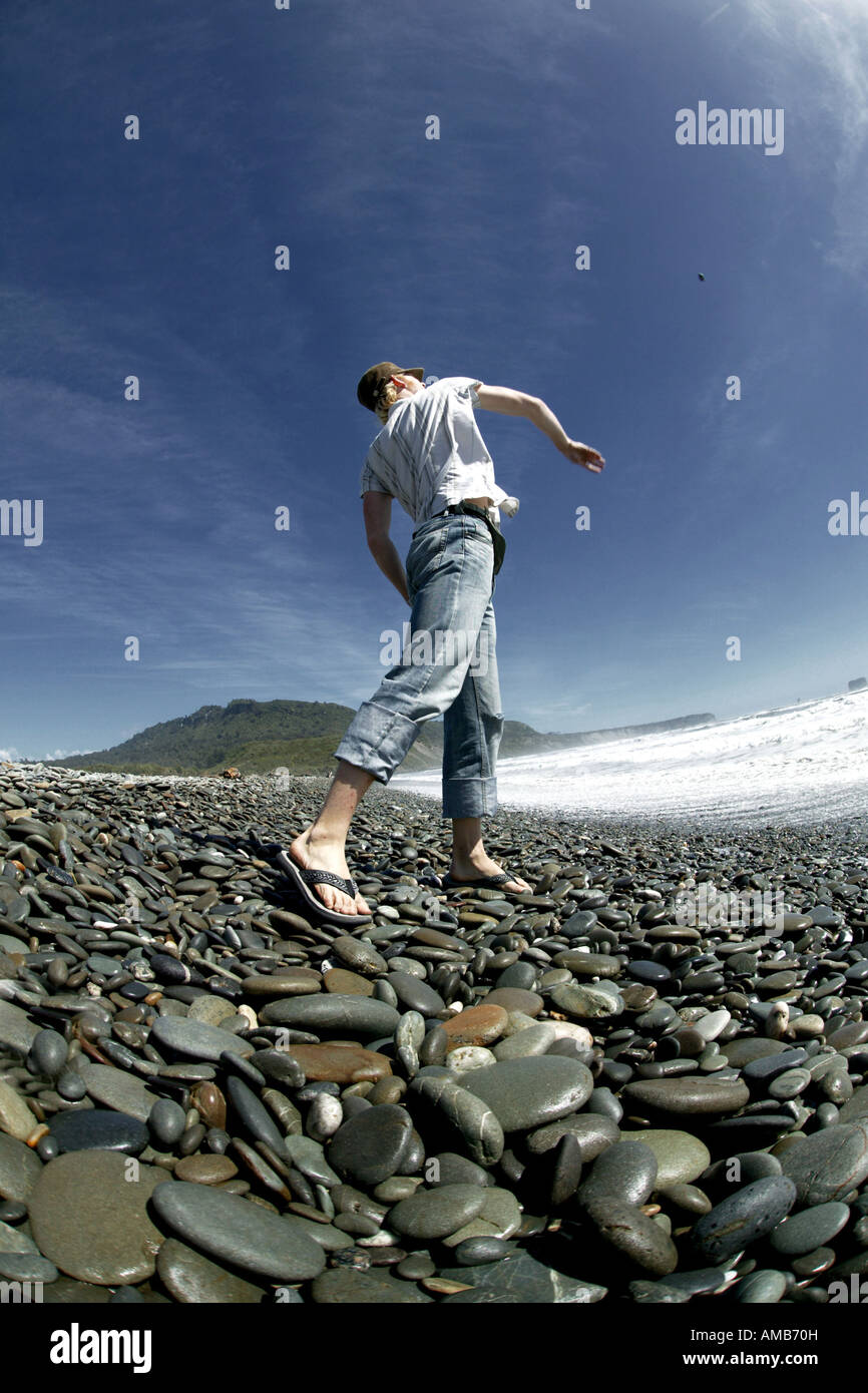 joung man throwing a stone into the sea Stock Photo - Alamy