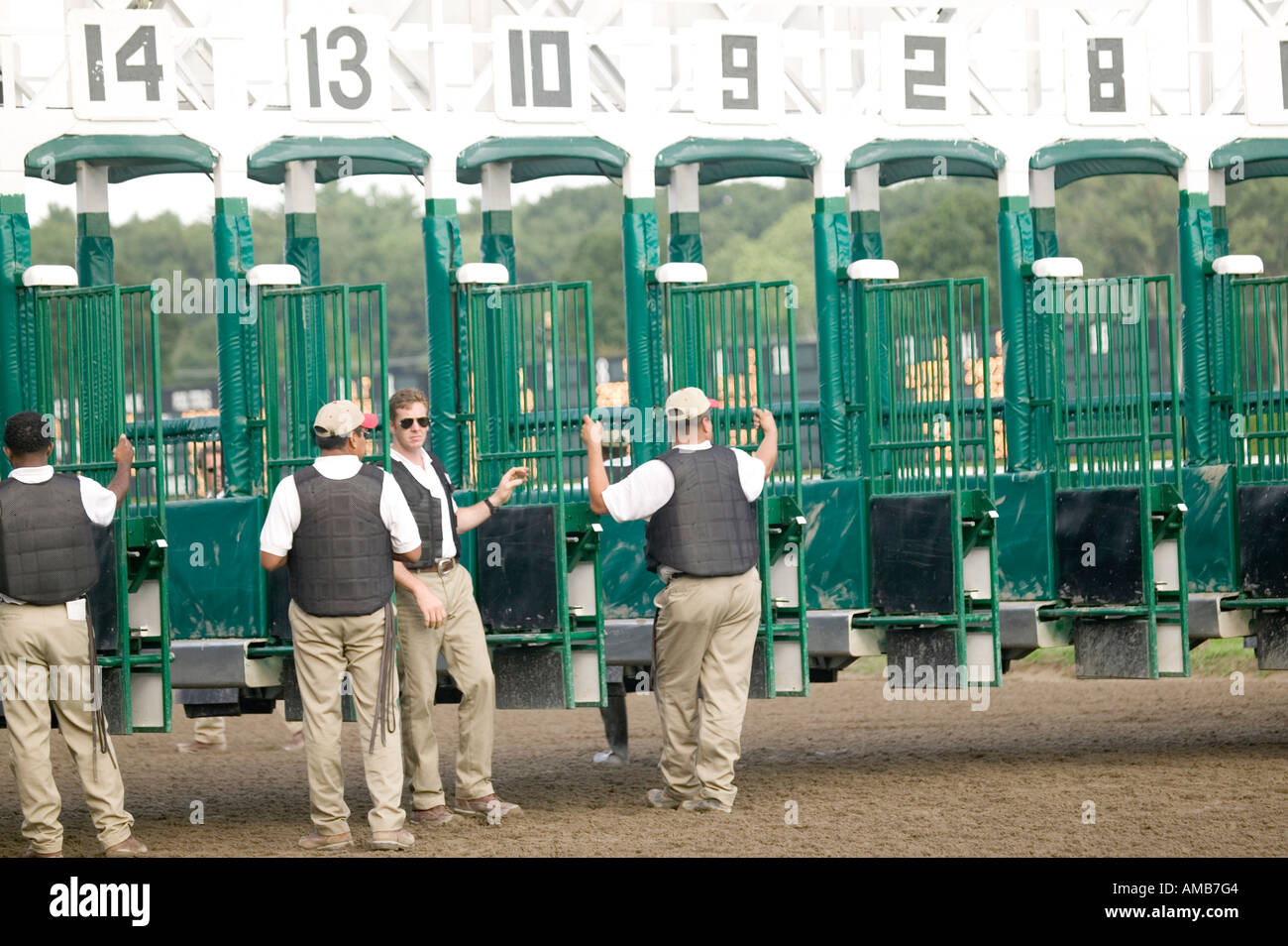 Handlers wait for jockeys and horses at the starting boxes at the ...