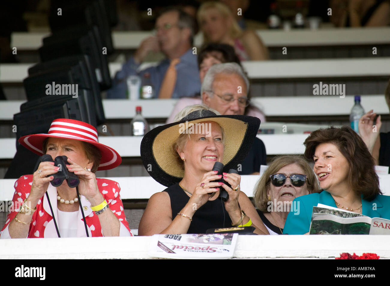 Elegant spectators follow horse races from the owners grandstand at the ...