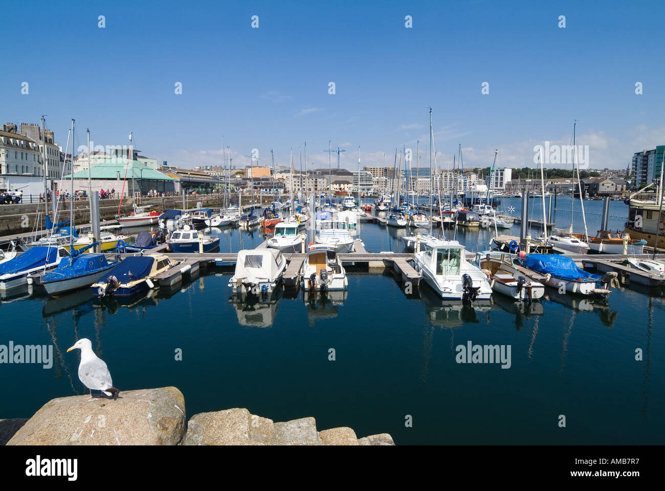 Boats moored in Sutton Harbour next to the historic Barbican which ...