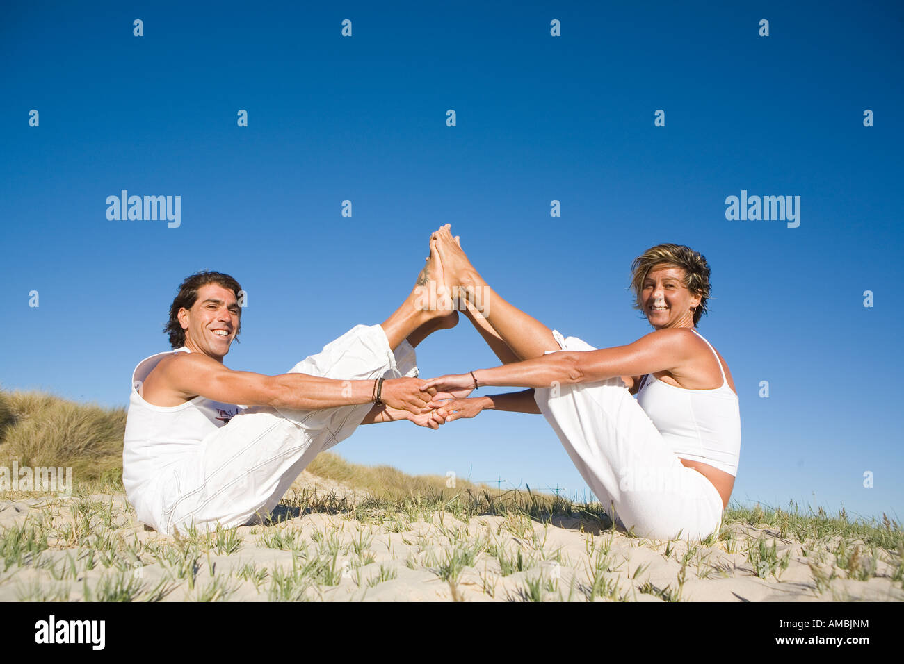 man and woman stretching with feet together and holding hands Stock ...