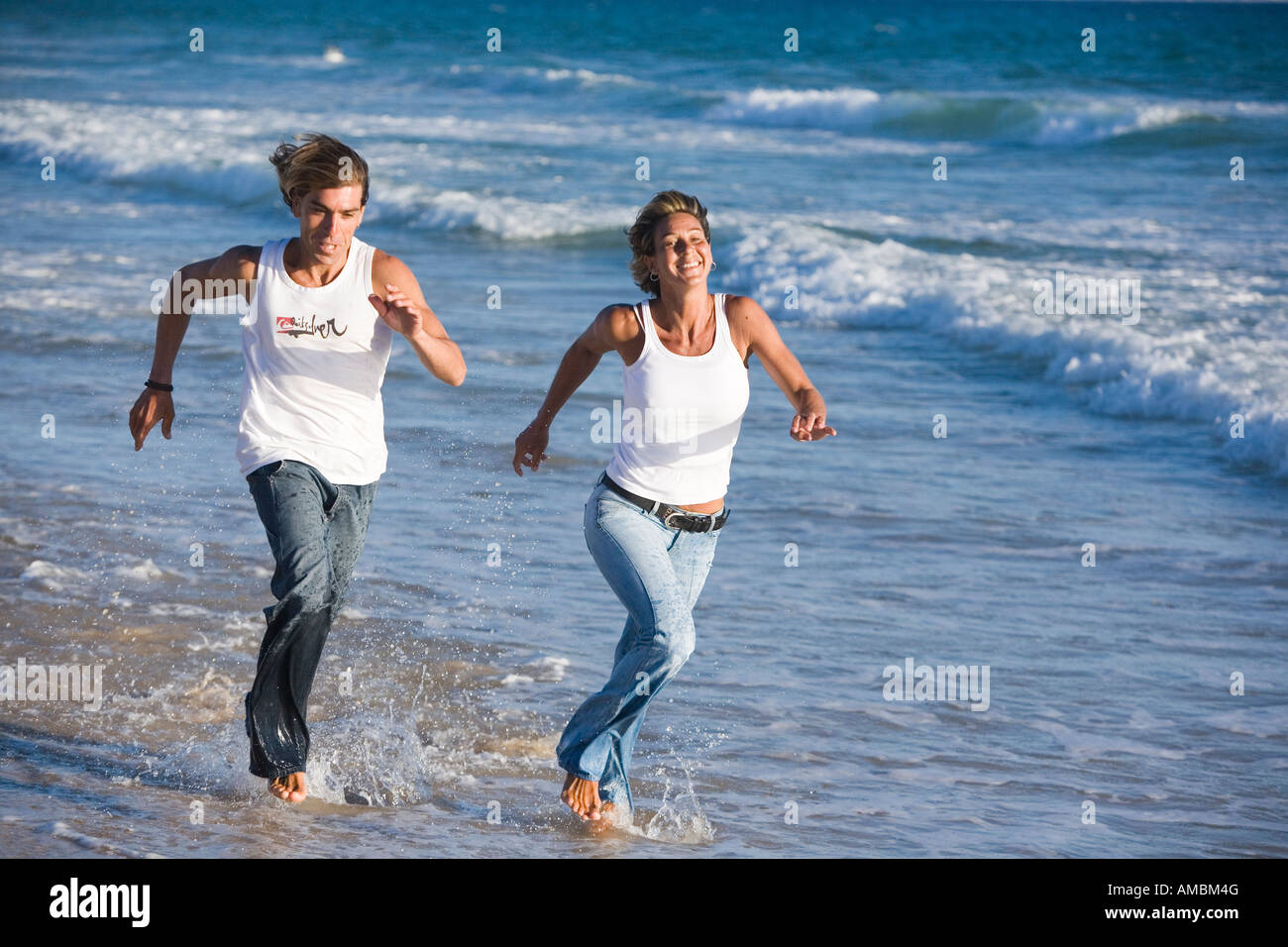 couple racing each other on sea shore Stock Photo - Alamy