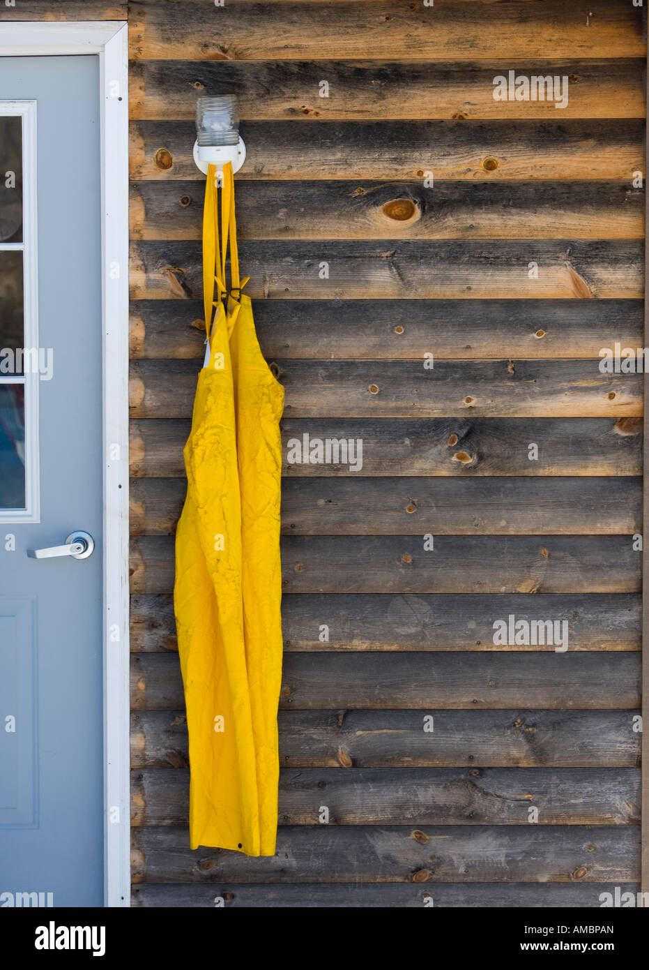 Yellow overalls hanging on a building Stock Photo - Alamy