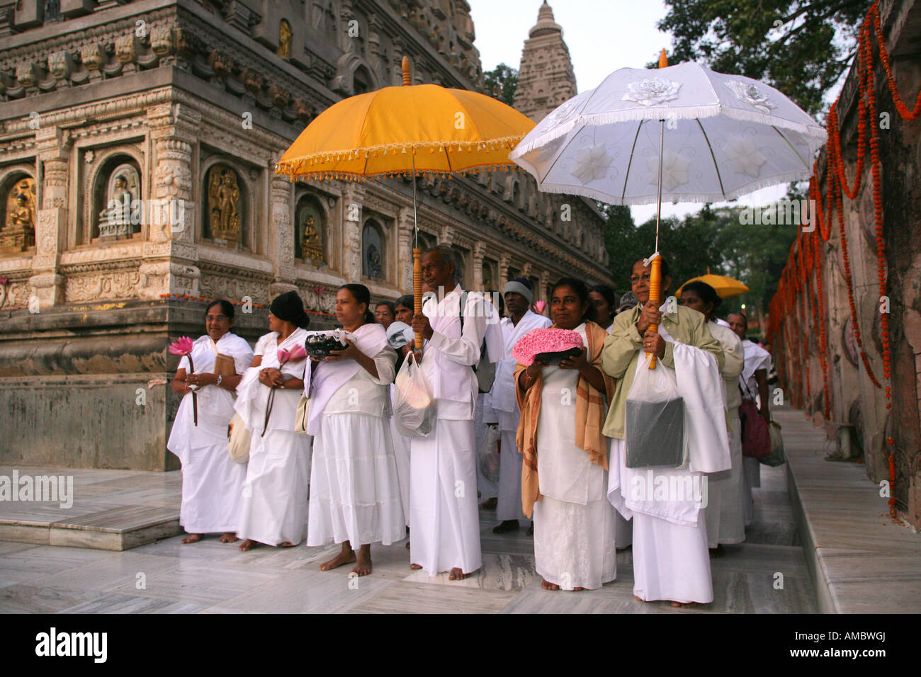 India, Bodhgaya: buddhist pilgrims walk around the Mahabodhi temple in ...