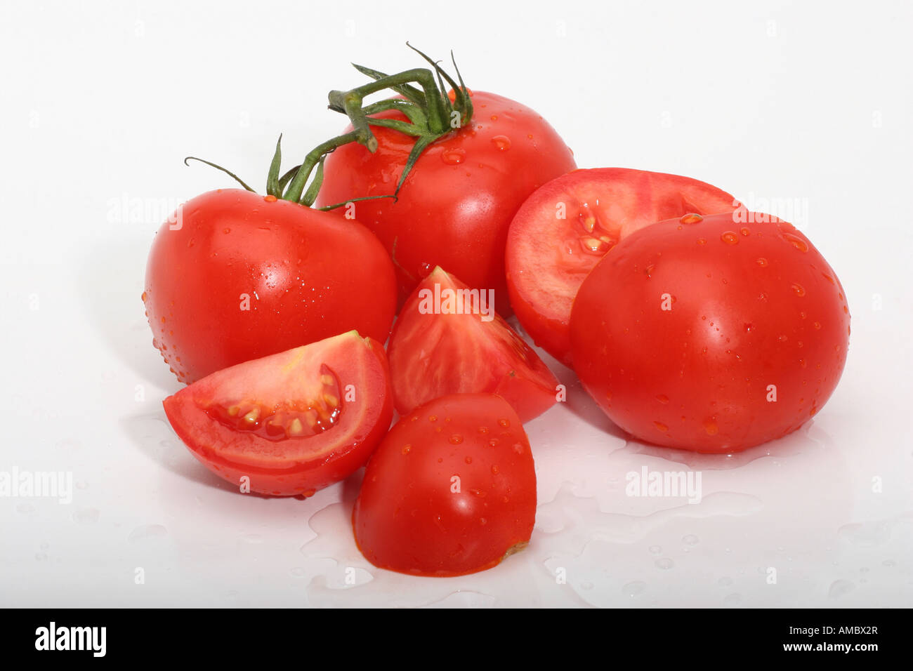 Ripe red cherry tomatoes whole and pieces with water drops cross section from above nobody ...